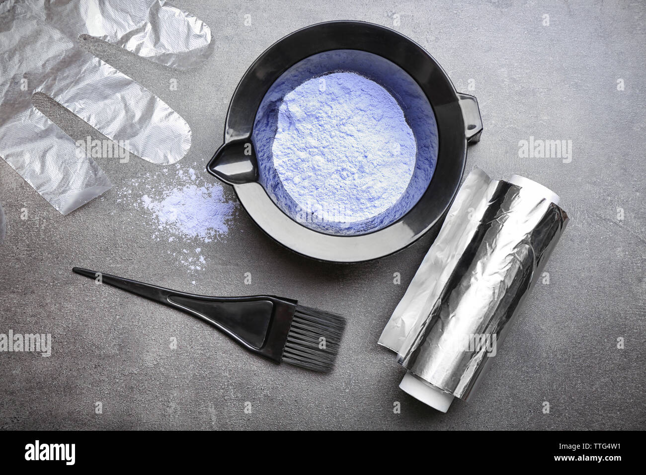 Barber set with hair dye, foil and brush on grey background Stock Photo ...