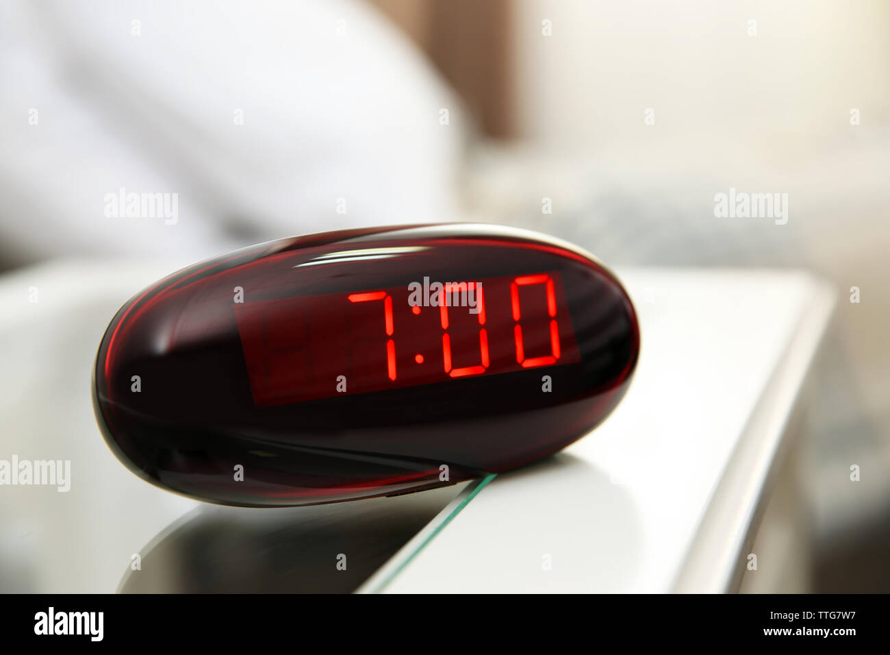 Digital clock on a bedside table in bedroom Stock Photo - Alamy