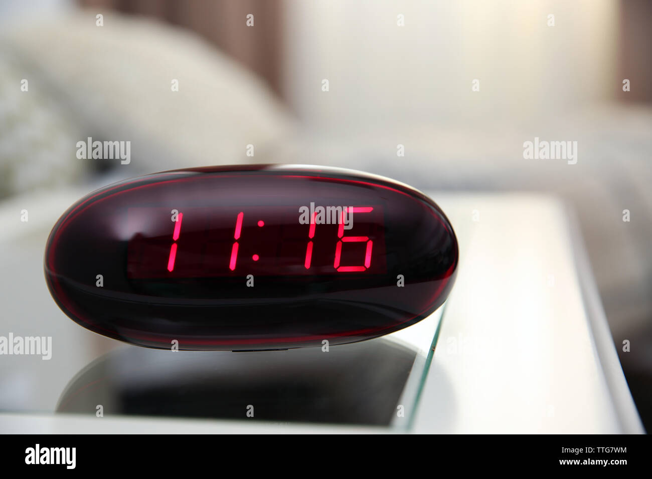 Digital clock on a bedside table in bedroom Stock Photo - Alamy
