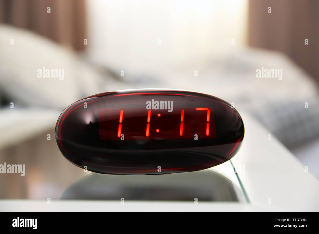 Digital clock on a bedside table in bedroom Stock Photo - Alamy
