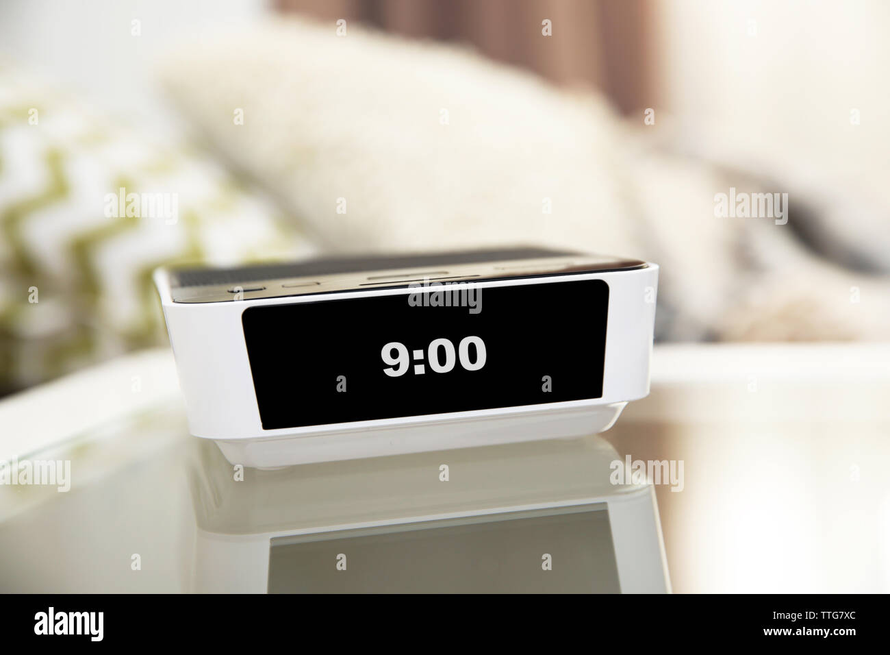 Digital clock on a bedside table in bedroom Stock Photo - Alamy