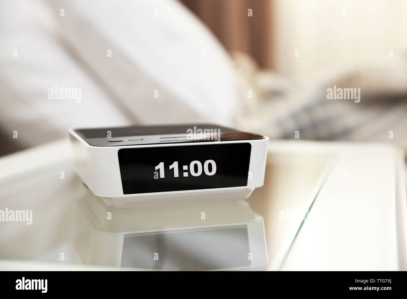 Digital clock on a bedside table in bedroom Stock Photo - Alamy