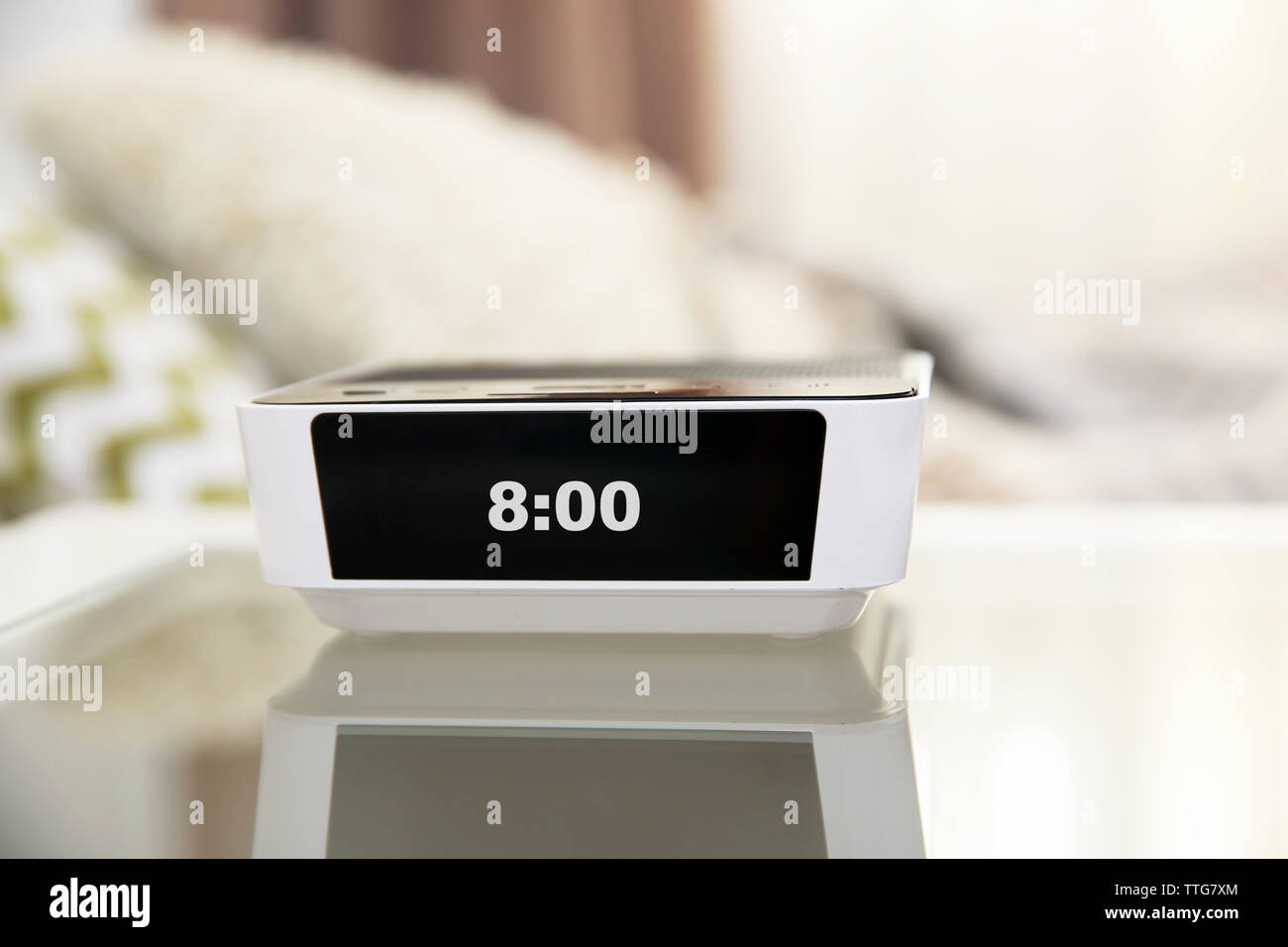 Digital clock on a bedside table in bedroom Stock Photo - Alamy