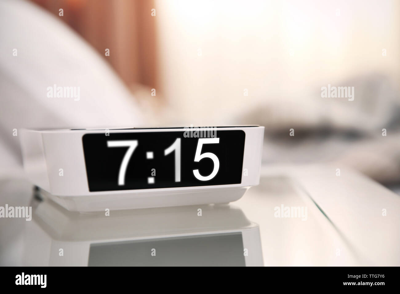 Digital clock on a bedside table in bedroom Stock Photo - Alamy