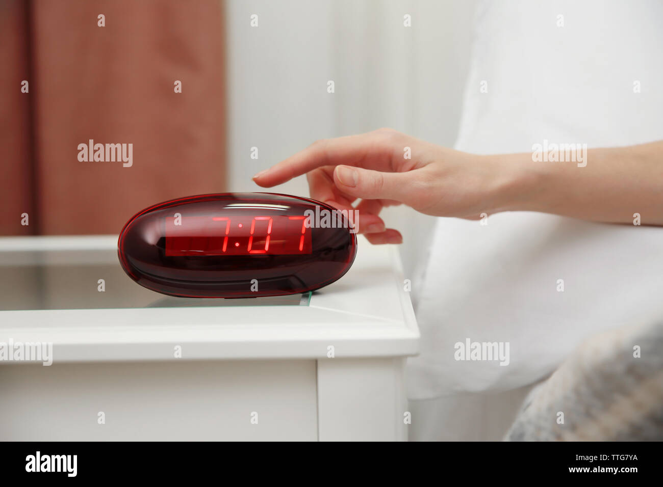 Female hand trying to stop digital clock ringing Stock Photo - Alamy