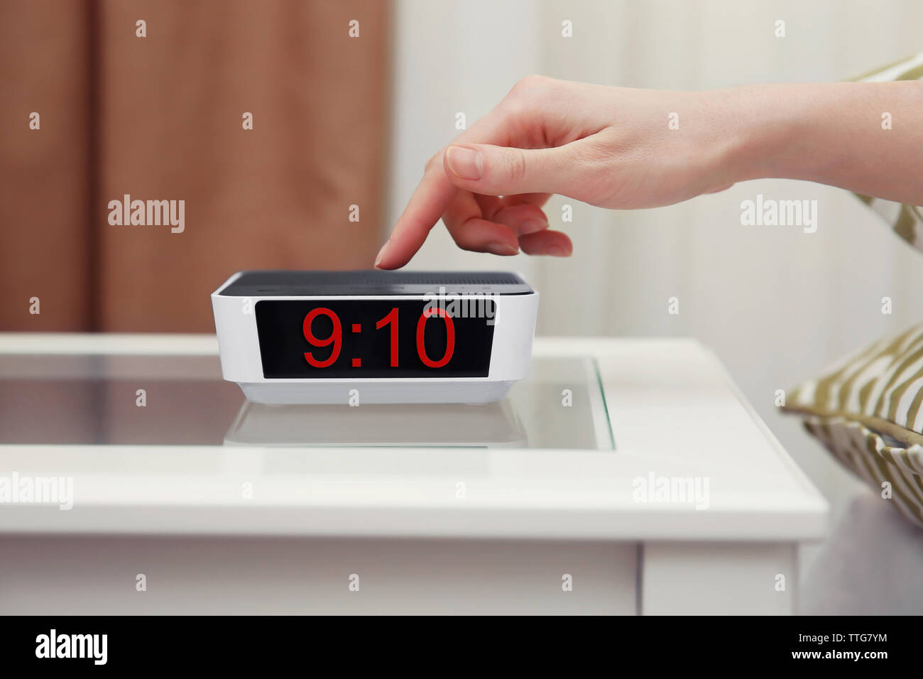 Female hand trying to stop digital clock ringing Stock Photo - Alamy