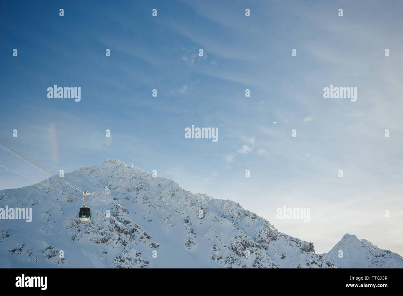 A telecabin leaves a mountain peak in winter Stock Photo - Alamy