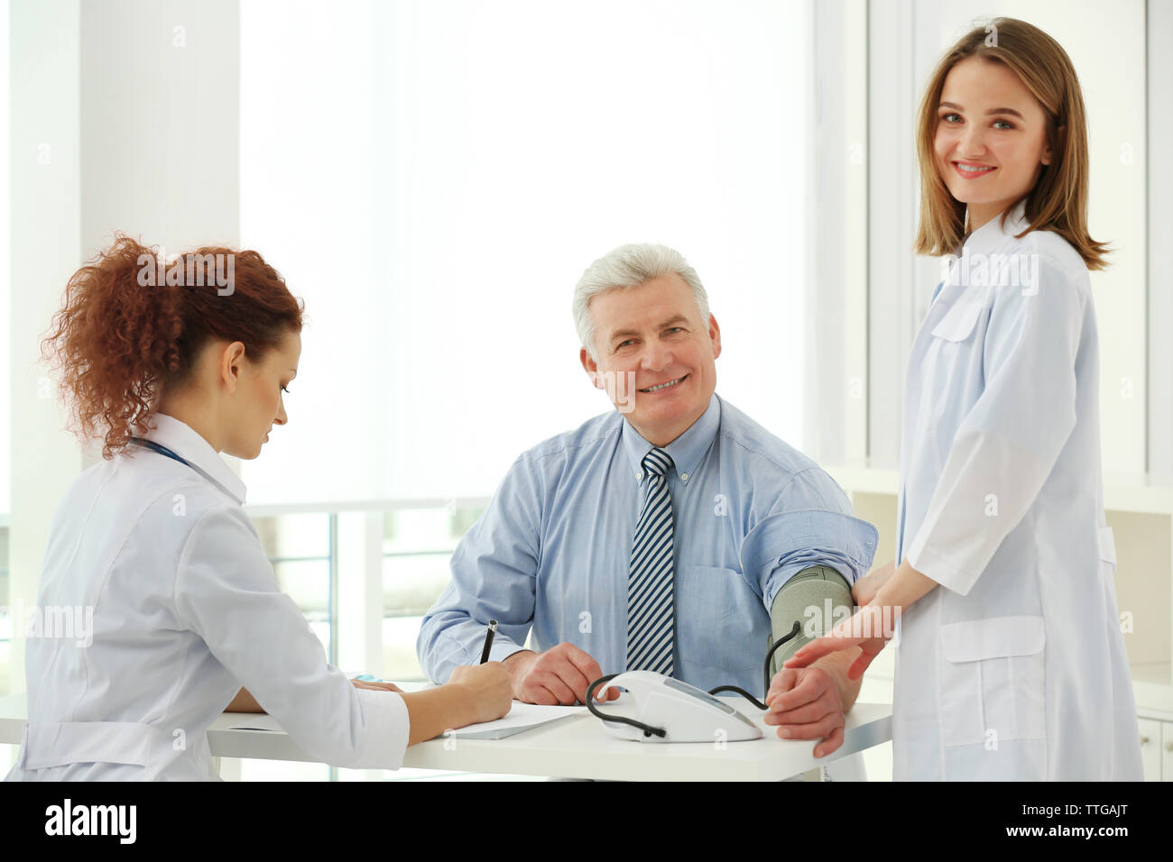 Doctors and patient in office Stock Photo - Alamy