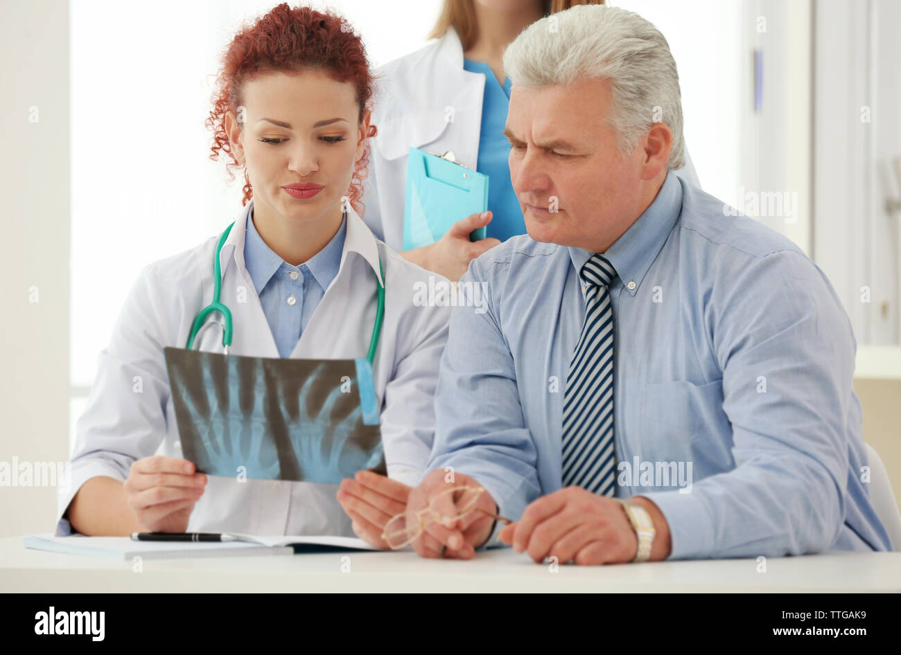 Doctors and patient in office Stock Photo - Alamy