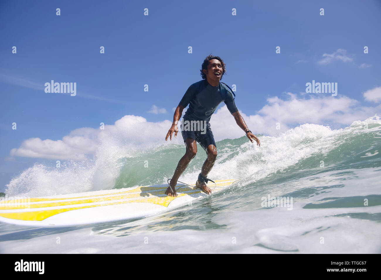 Portrait of carefree smiling man surfing in sea Stock Photo - Alamy