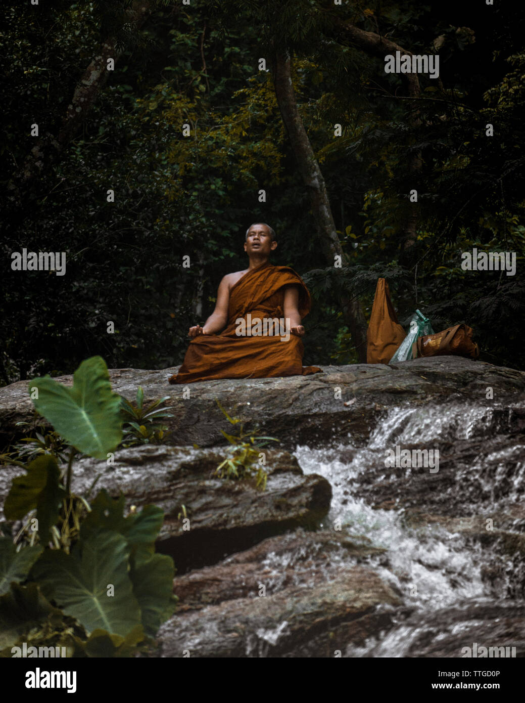 Meditating Monk in Waterfall Stock Photo - Alamy
