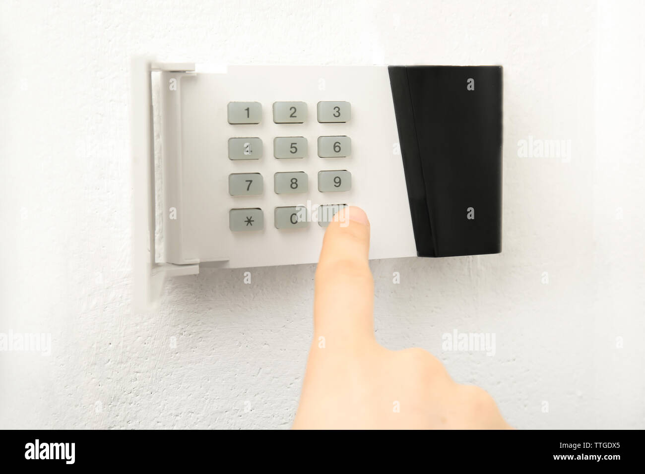 Security alarm keypad with male hand, closeup Stock Photo - Alamy