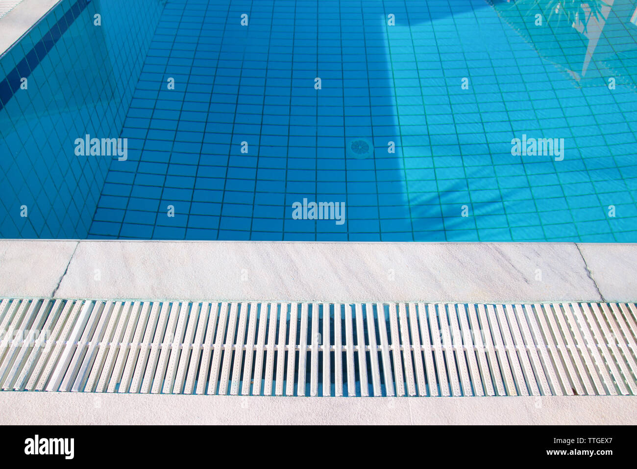 Blue ripped water in swimming pool in tropical resort with edge of ...