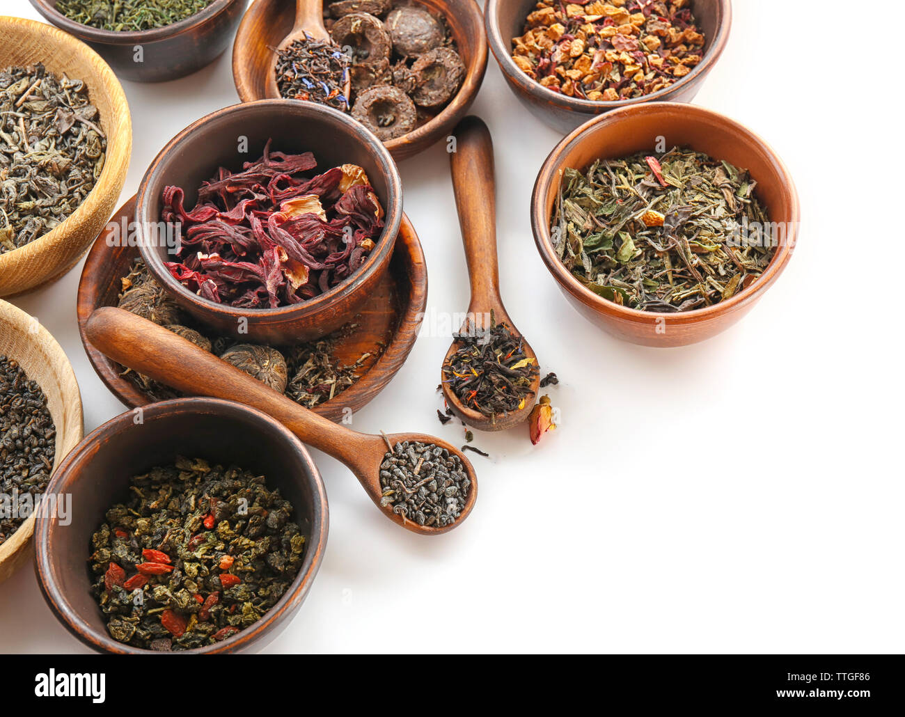 Variety of dry tea in pots and wooden spoons isolated on white Stock ...