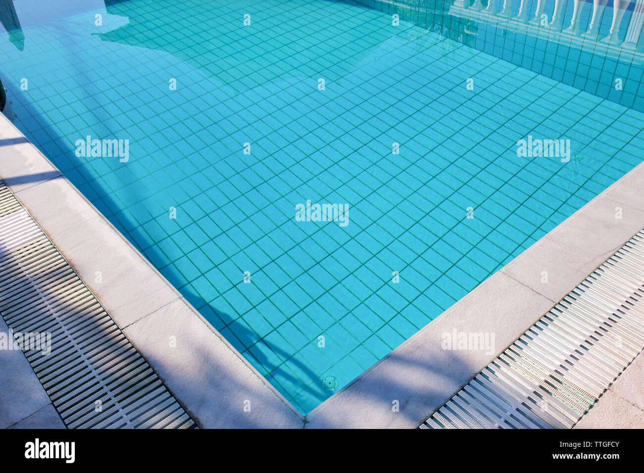 Blue ripped water in swimming pool in tropical resort with edge of ...