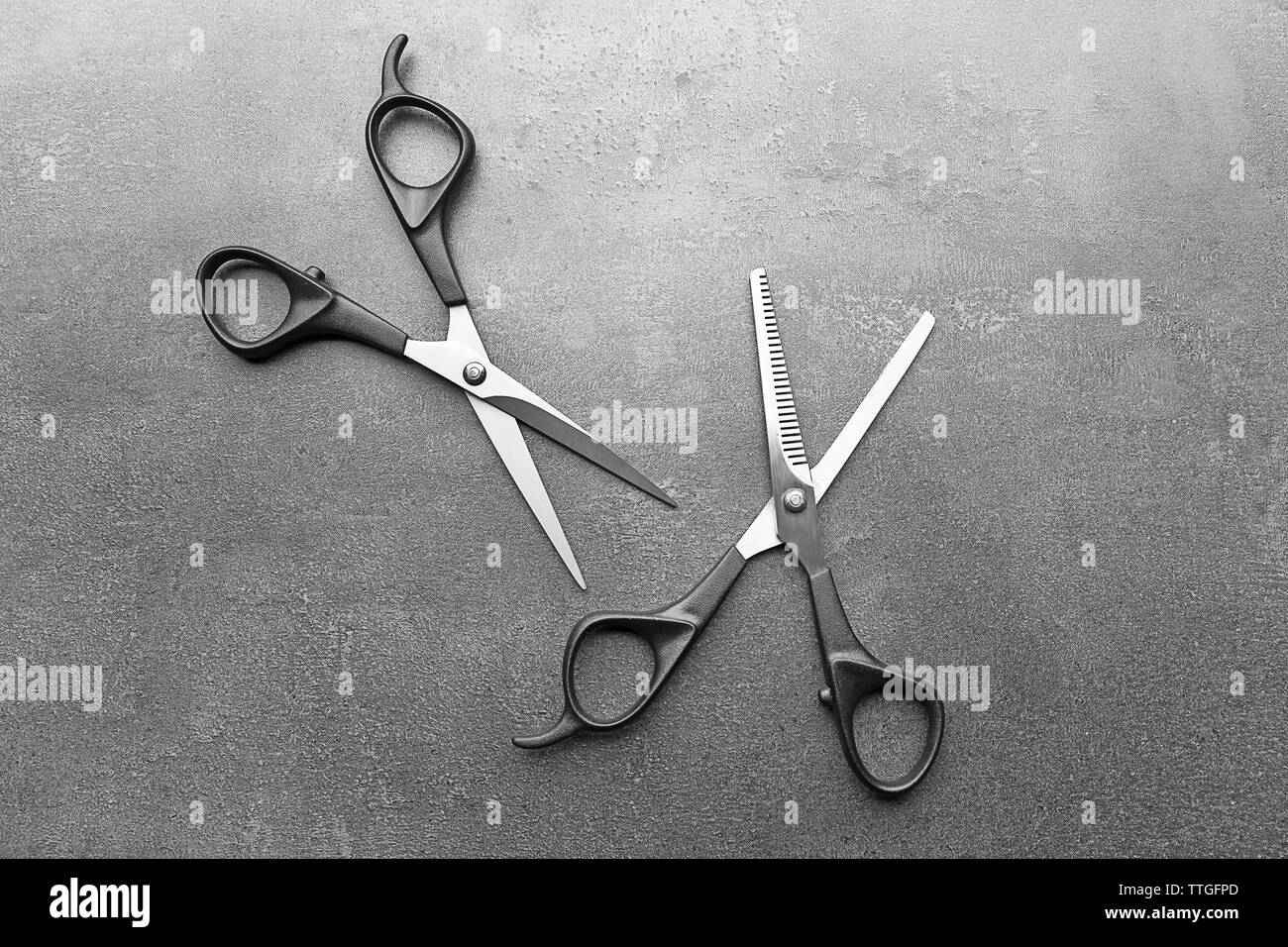 Professional scissors with black handles on a dark grey surface, top ...