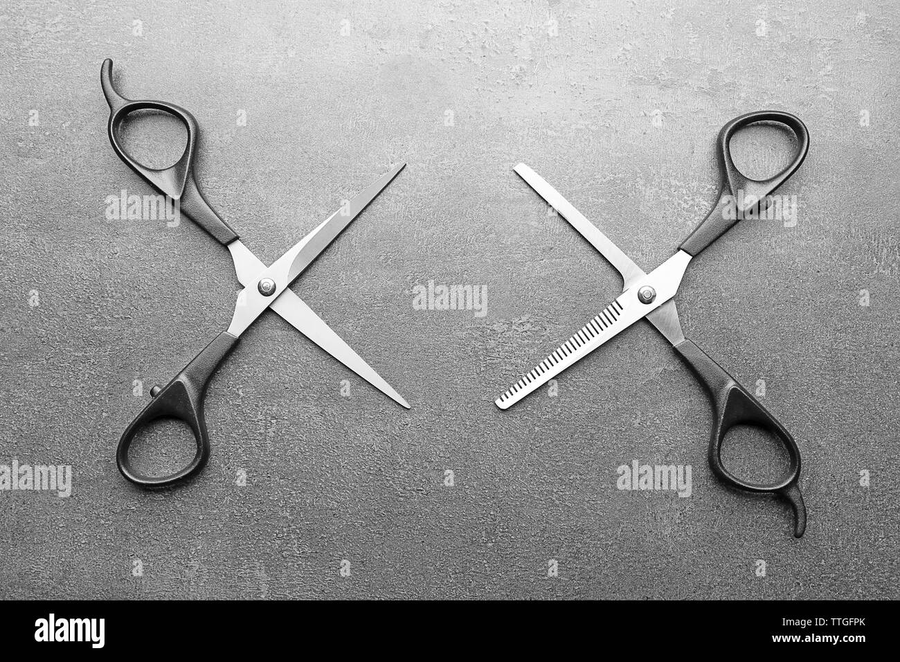 Professional scissors with black handles on a dark grey surface, top ...