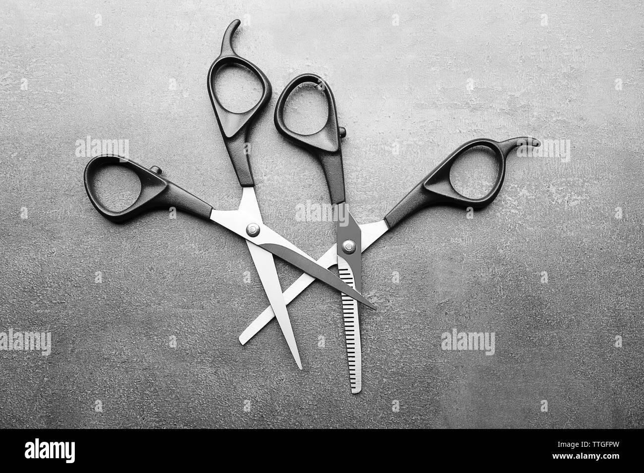 Professional scissors with black handles on a dark grey surface, top ...