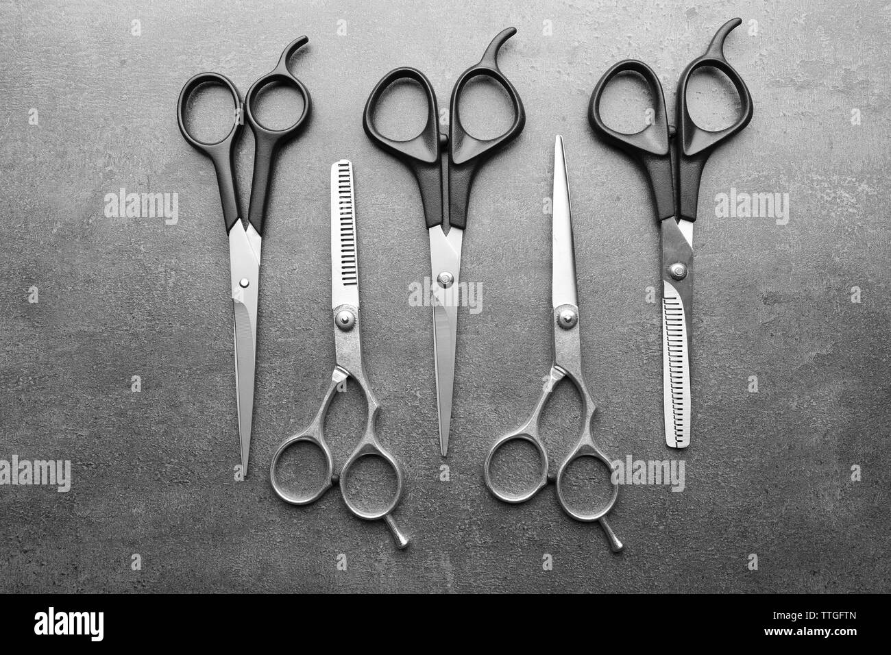 Professional metal scissors in different positions on a dark grey ...