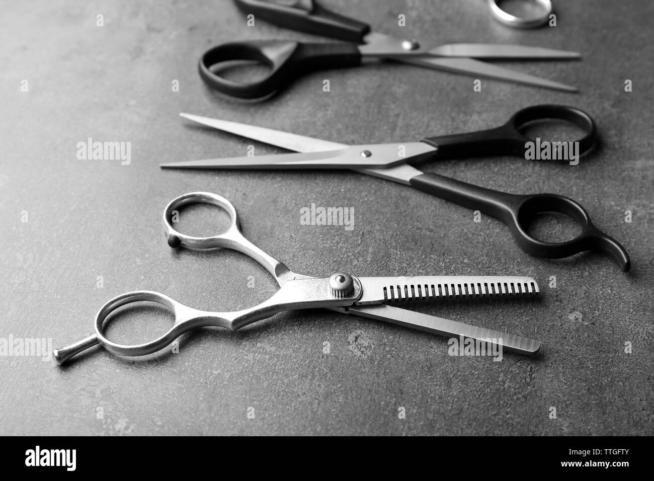Three professional scissors with black and metal handles in open ...