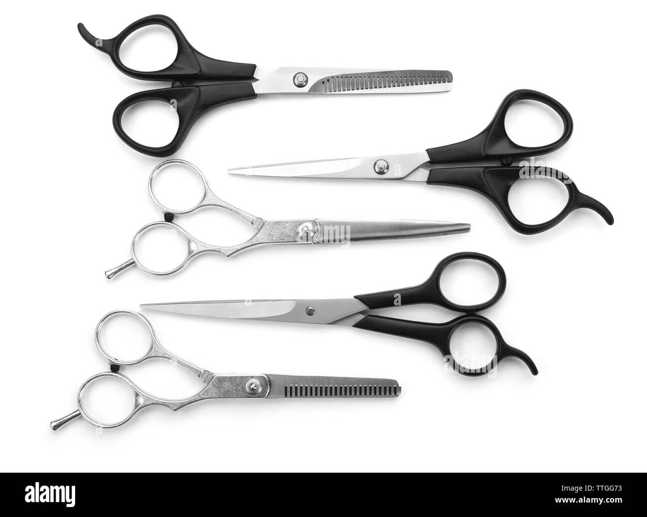 Professional scissors with black and metal handles in shut positions ...