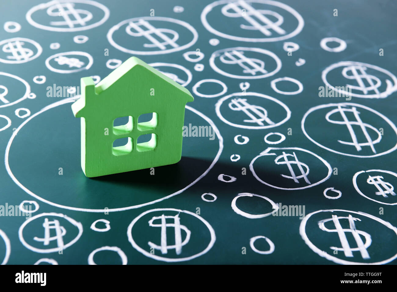 House figure and painted dollar symbols on chalkboard,closeup Stock ...