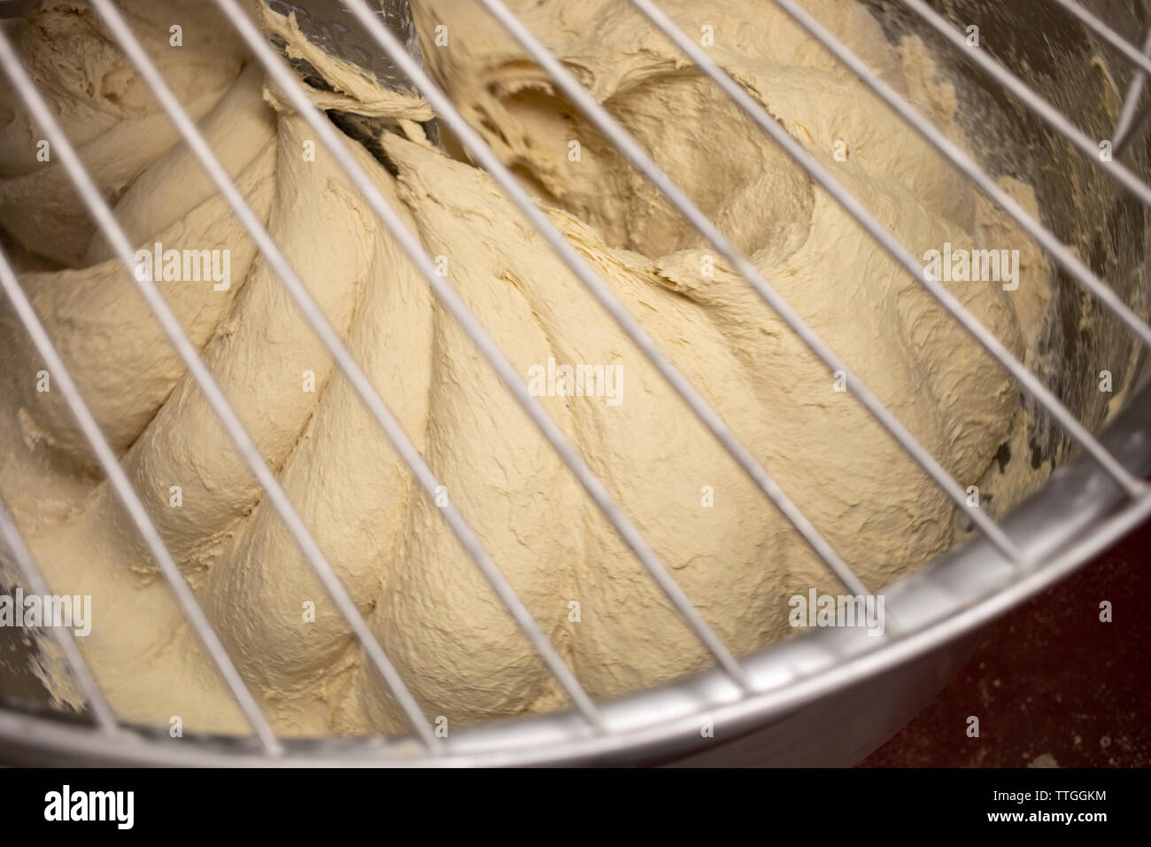 A large ball of raw bread dough is twisted in a mixer Stock Photo - Alamy