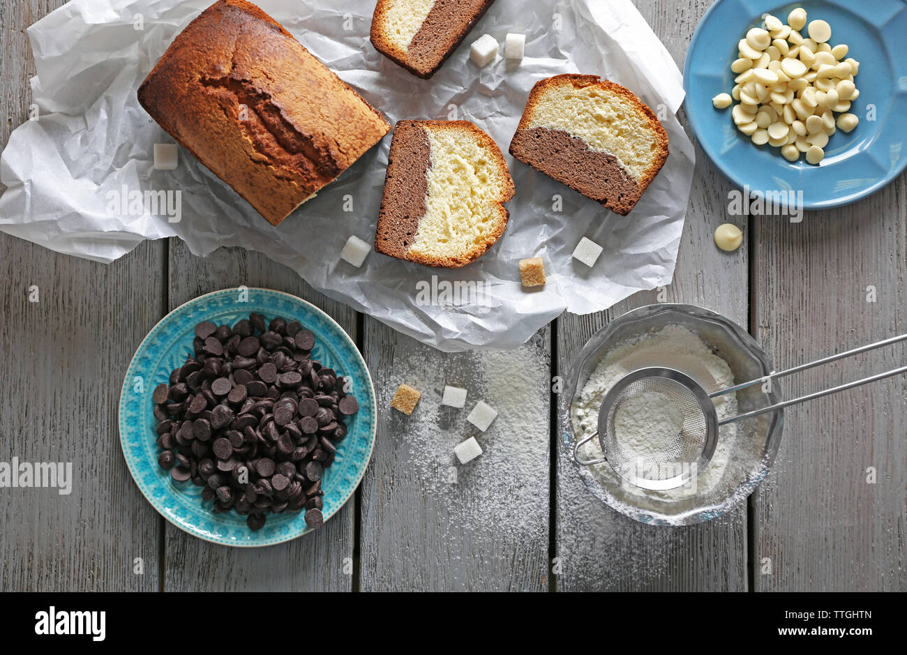 Composition of tasty cake with chocolate morsels and sugar on grey ...