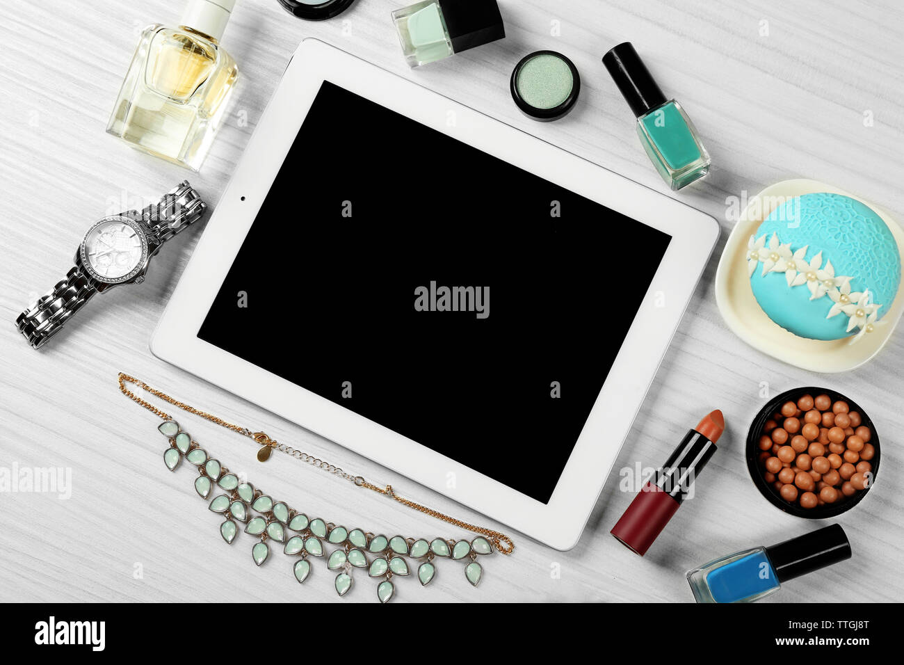 Digital tablet with woman's accessories on white wooden table ...