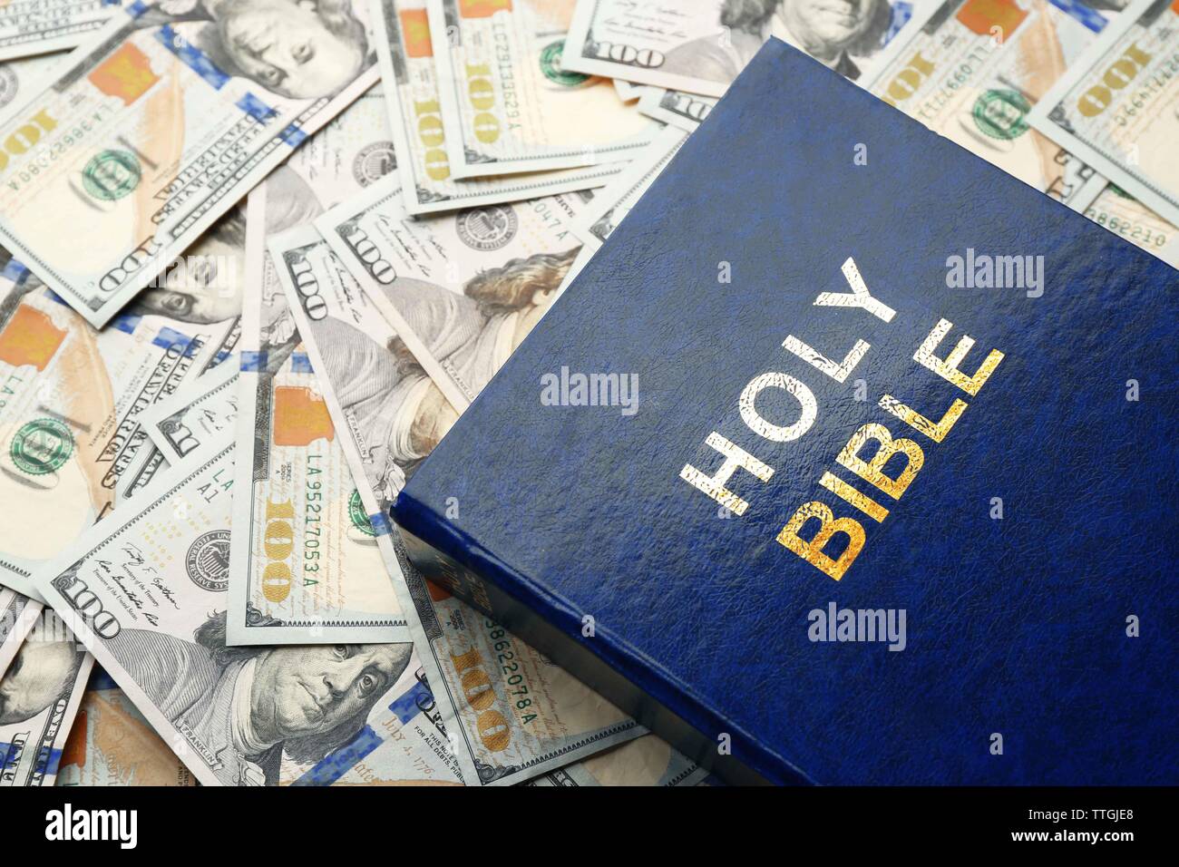 Holy Bible on money background, closeup Stock Photo - Alamy