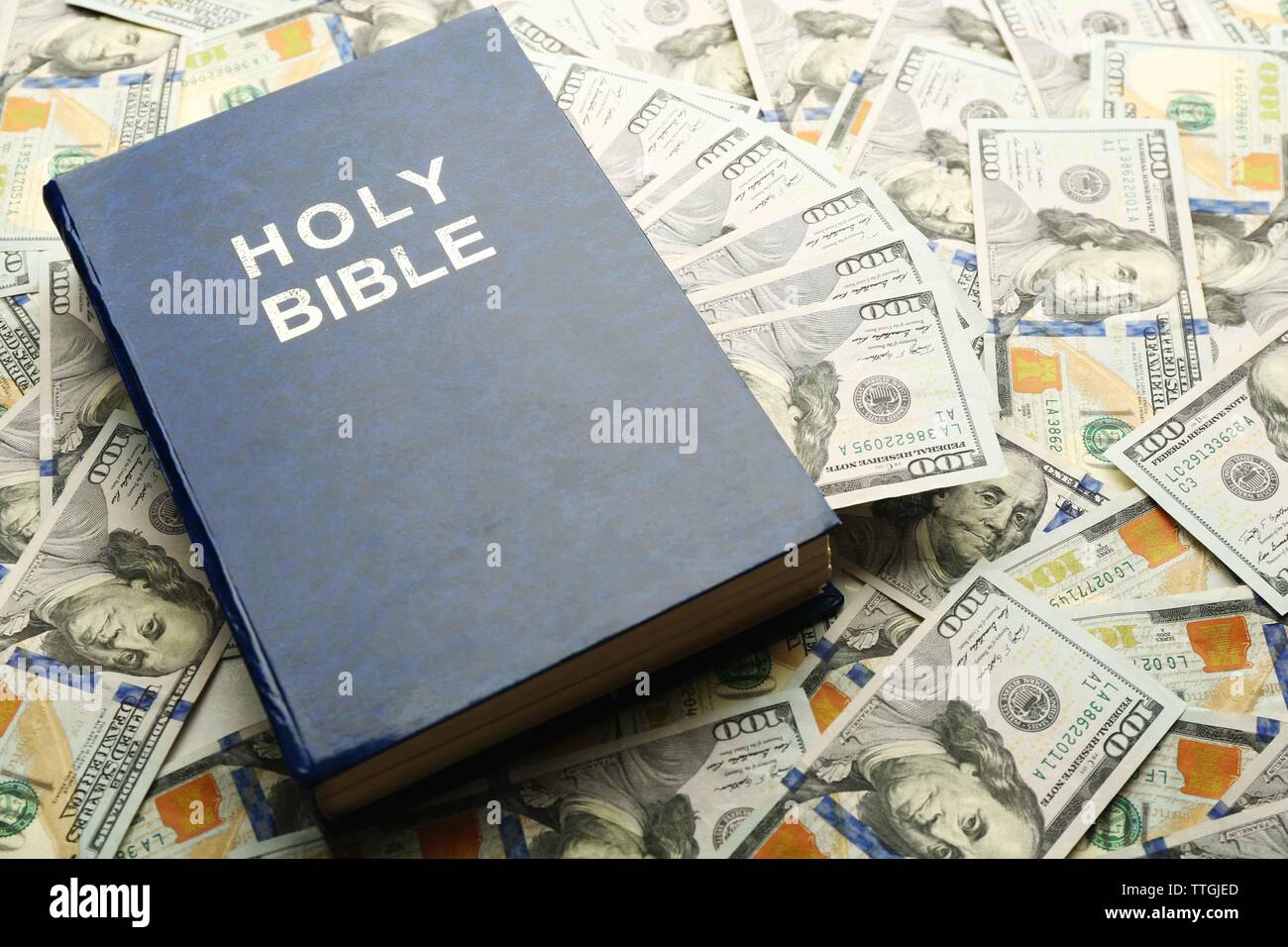 Holy Bible on money background, closeup Stock Photo - Alamy