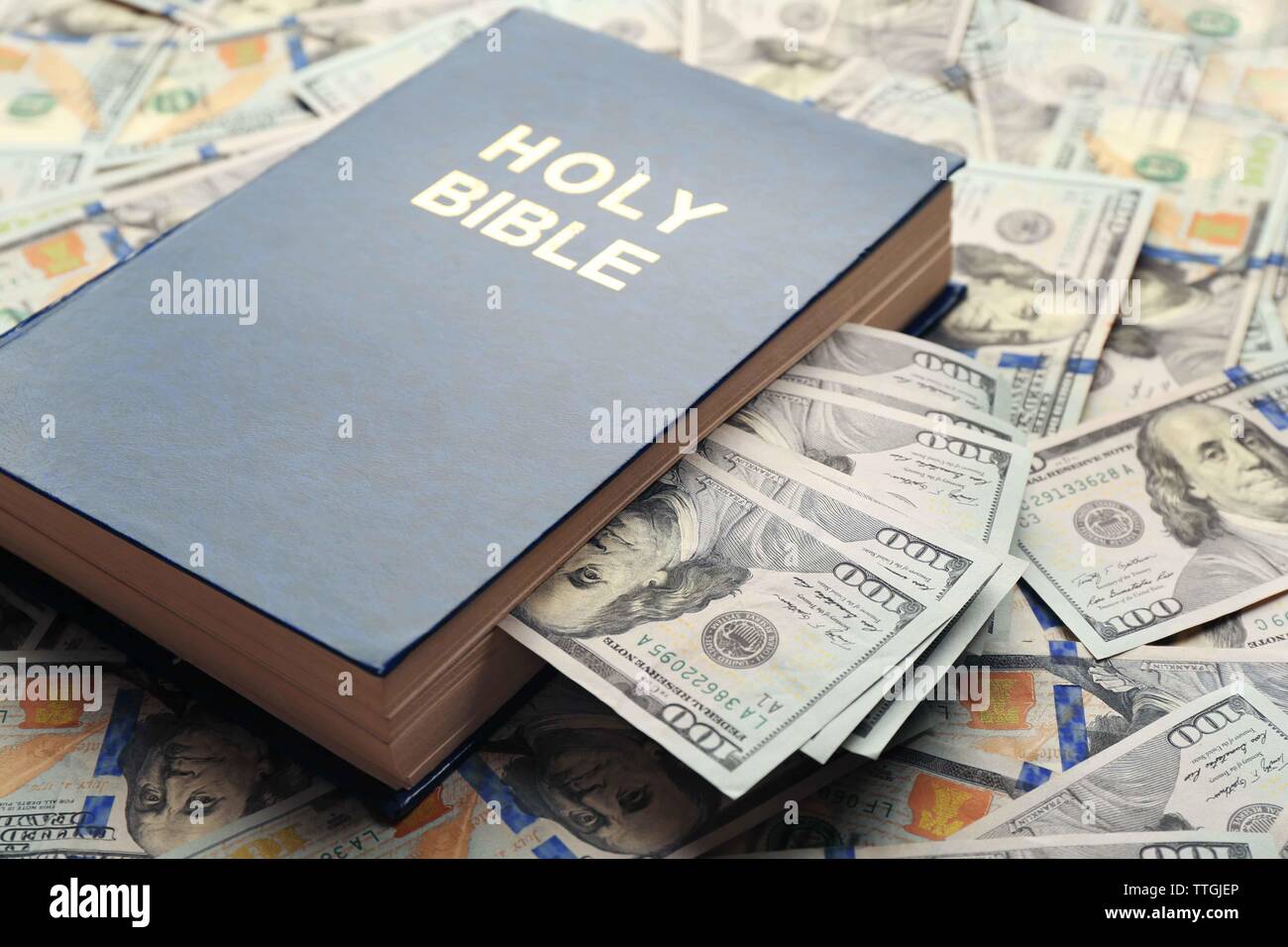 Holy Bible on money background, closeup Stock Photo - Alamy