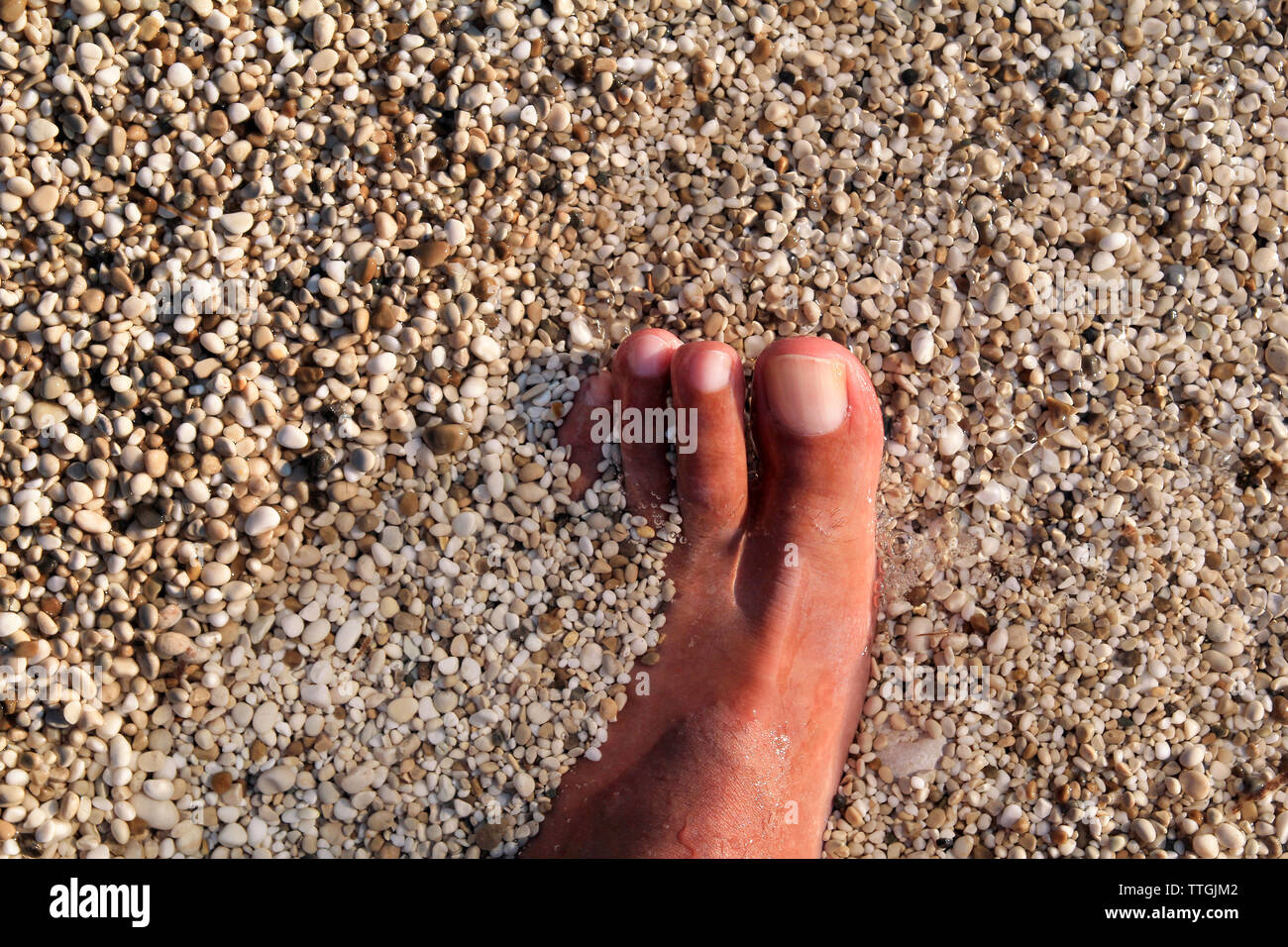 Top view of man standing bare feet on beach. Texture of bottom, leg and ...