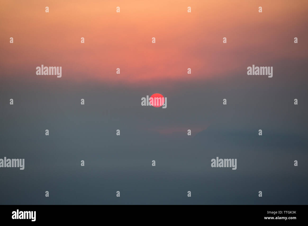 Sun rising through smoke and fog Stock Photo - Alamy