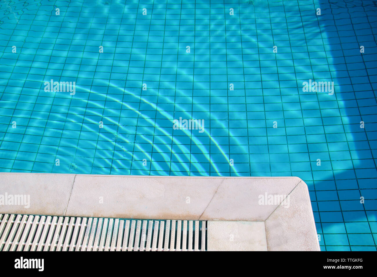 Blue ripped water in swimming pool in tropical resort with edge of ...