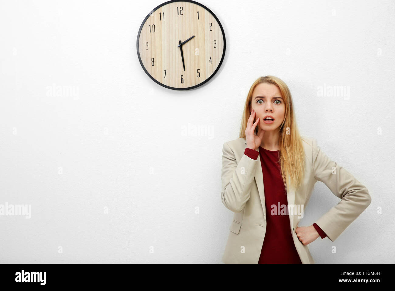 Young beautiful woman and clock on wall Stock Photo - Alamy