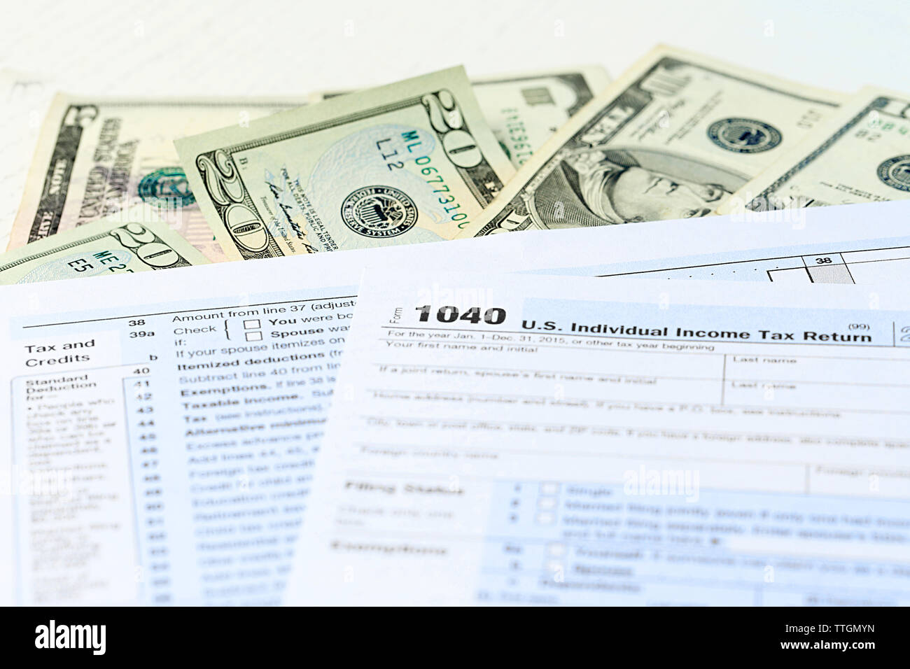 1040 Individual Income Tax Return Form with dollar bills on white ...