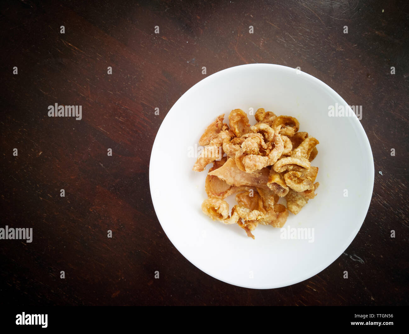 Close up of deep-fried chicken skins in a white bowl Stock Photo - Alamy