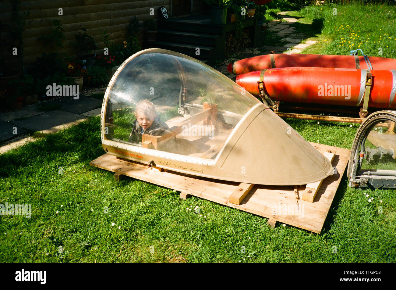 Two year old boy hiding in the cockpit canopy of a Strikemaster fighter ...