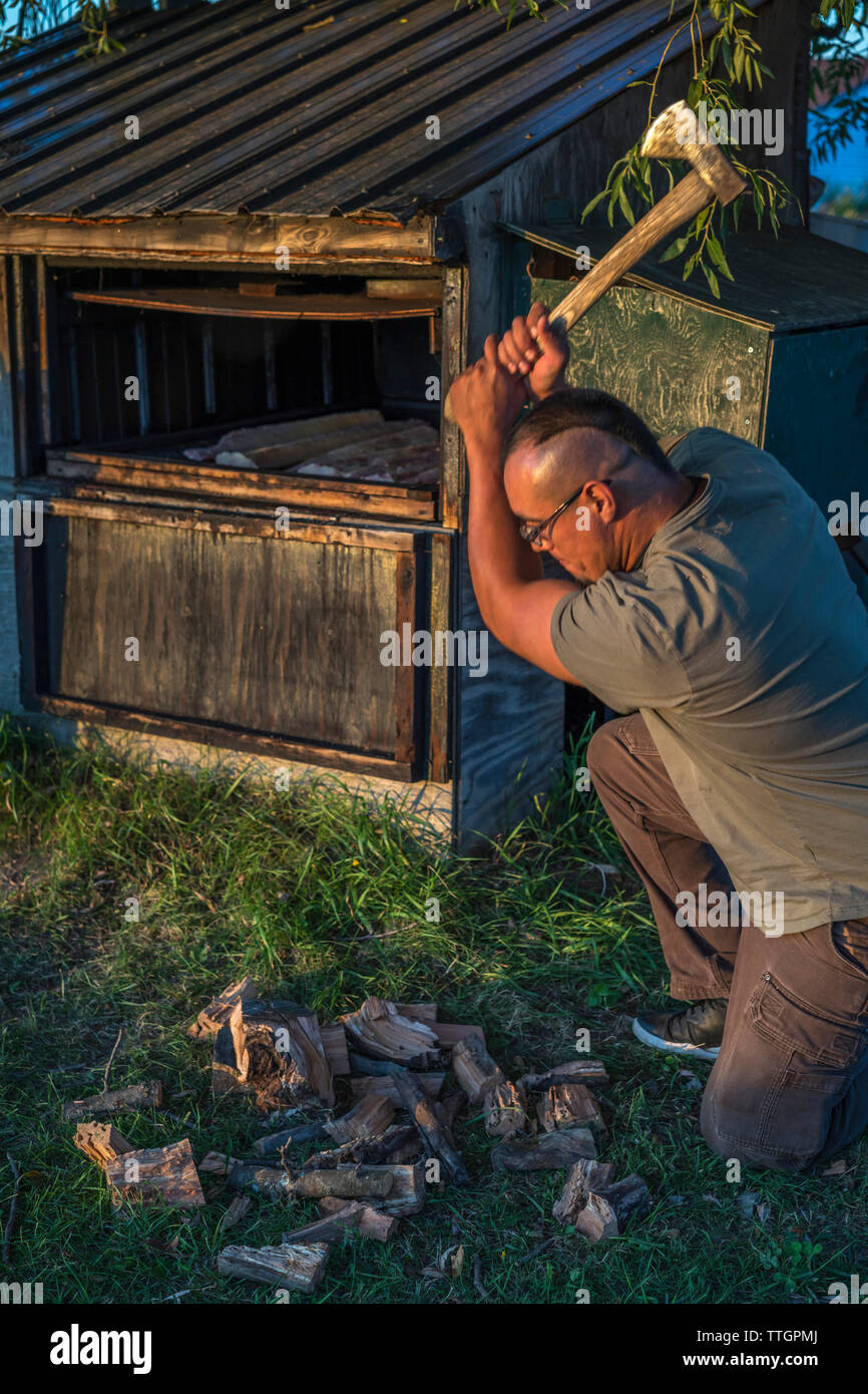Mohawk man chopping wood for smoking sturgeon, Akwesasne Stock Photo ...