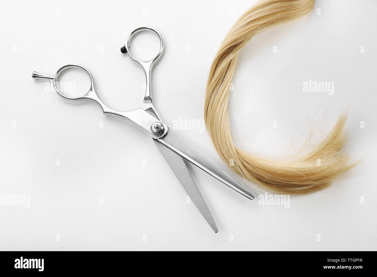 Hairdresser's scissors with strand of blonde hair, isolated on white ...