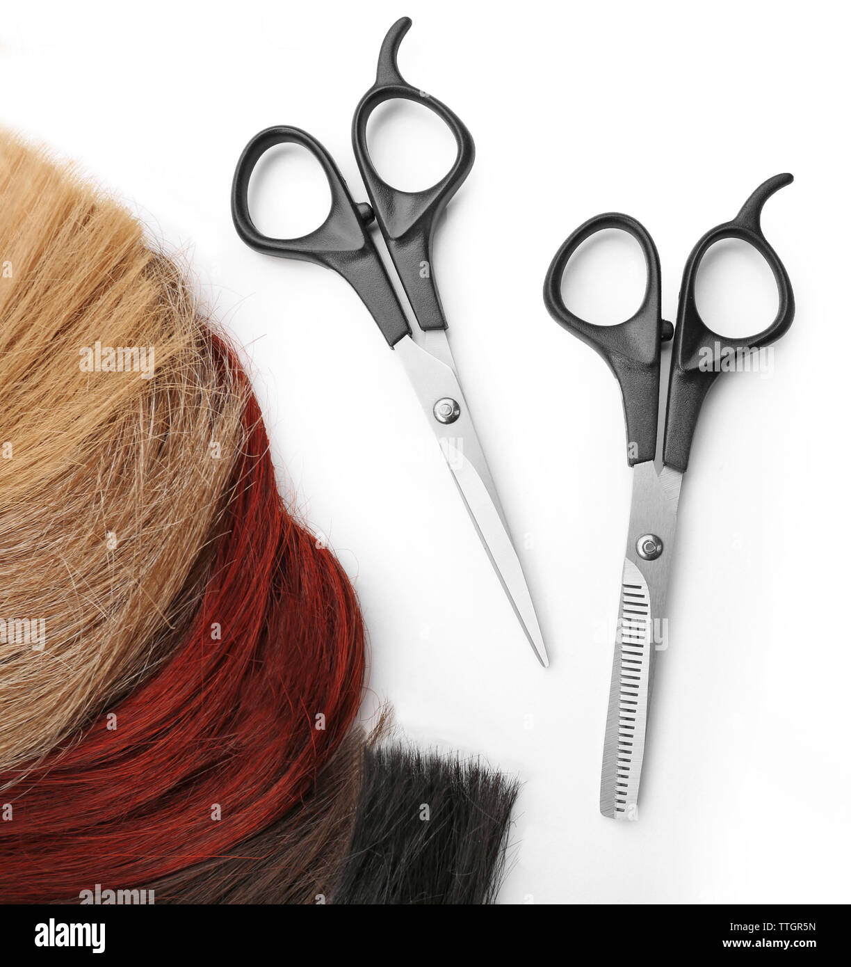Hairdresser's scissors with varicolored strands of hair, isolated on ...