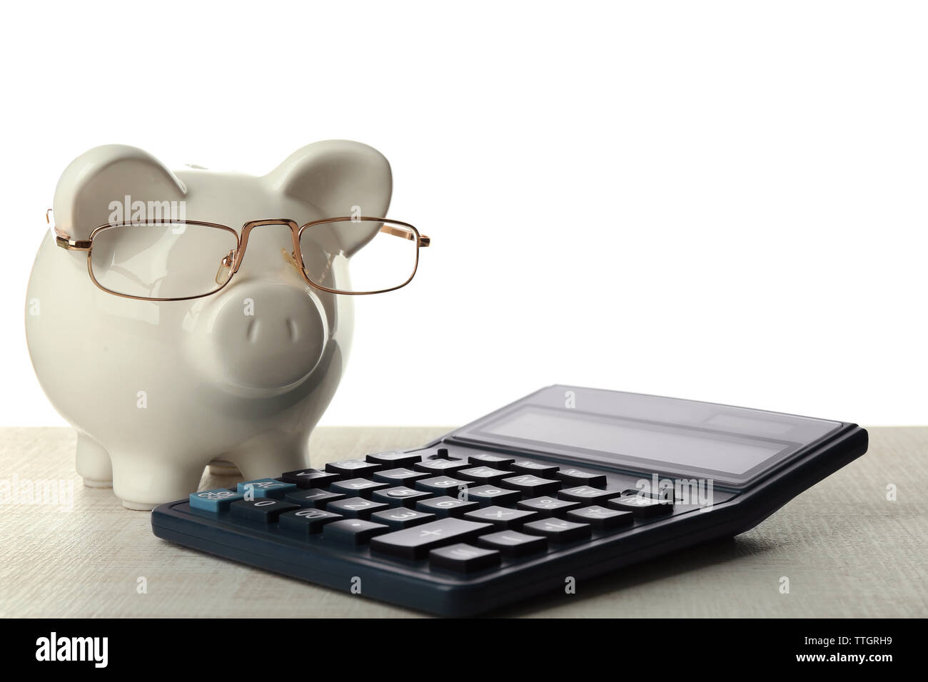 Piggy bank with glasses and calculator on white background Stock Photo ...