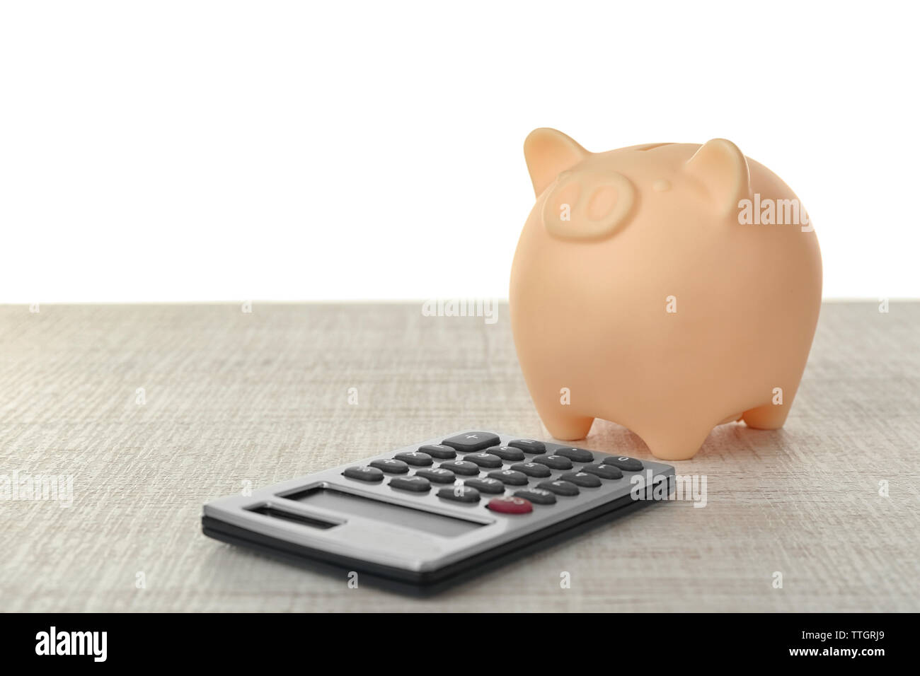 Beige piggy bank with calculator on white background Stock Photo - Alamy