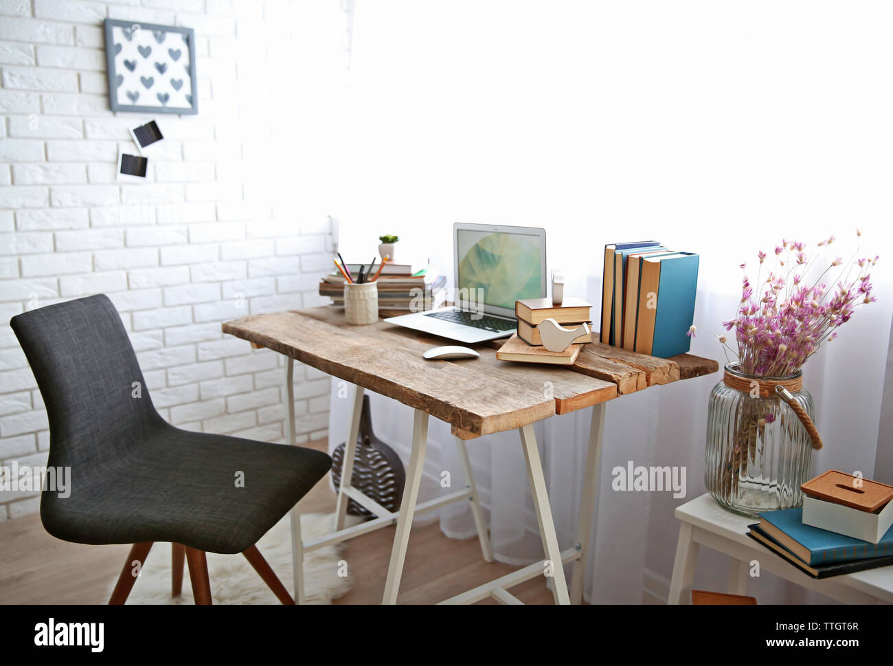 Workplace with laptop, table and chair beside the window Stock Photo ...