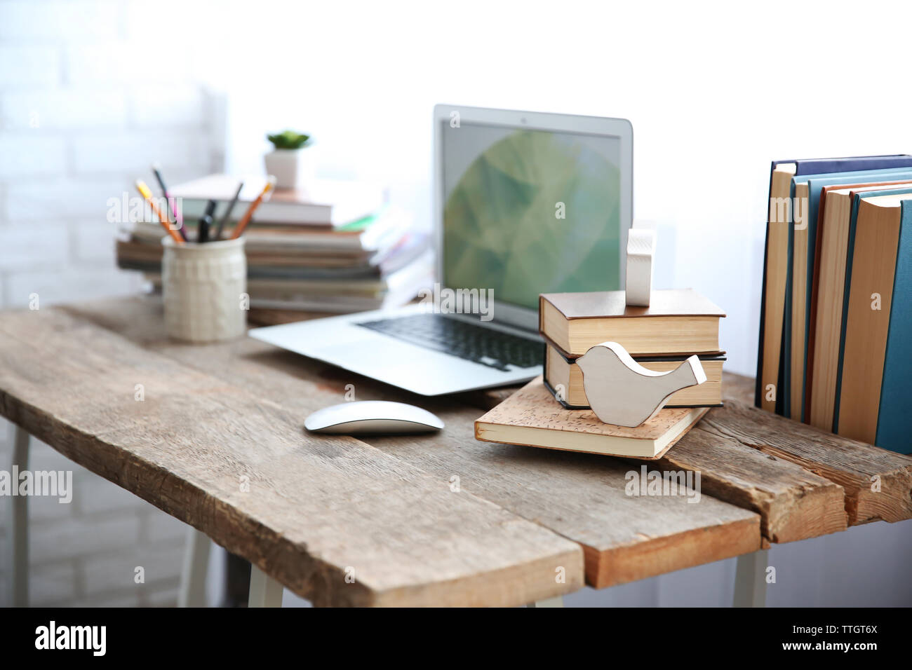 Workplace with laptop, table and books beside the window Stock Photo ...