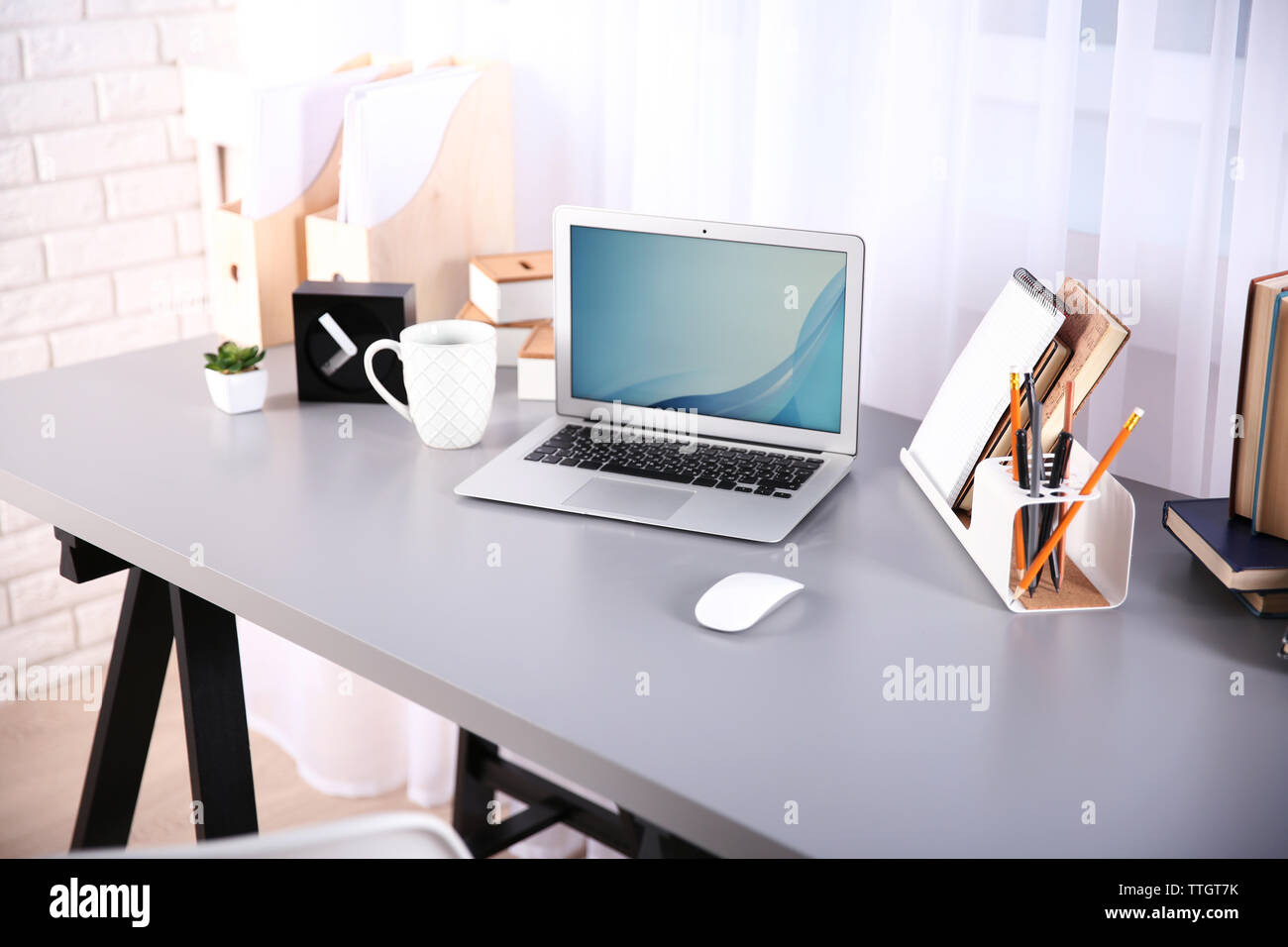 Workplace with laptop, table and books beside the window Stock Photo ...