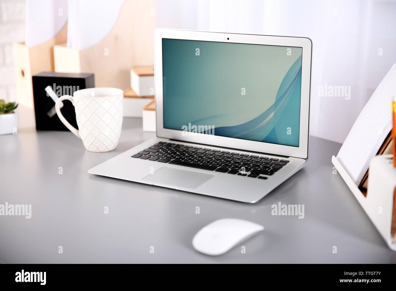 Workplace with laptop, table, mouse and cup beside the window Stock ...