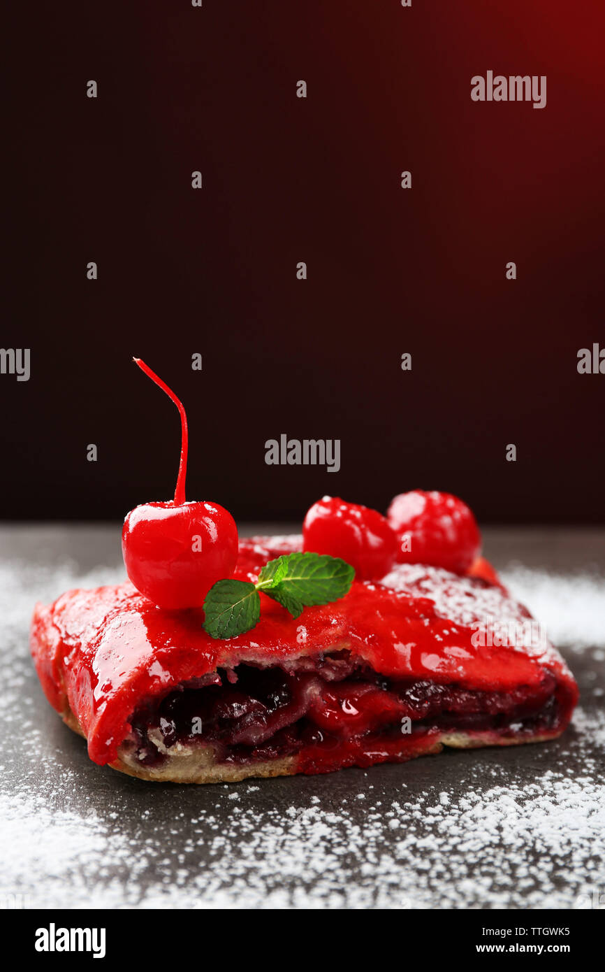 Powdered cherry strudel with mint on dark red background Stock Photo ...