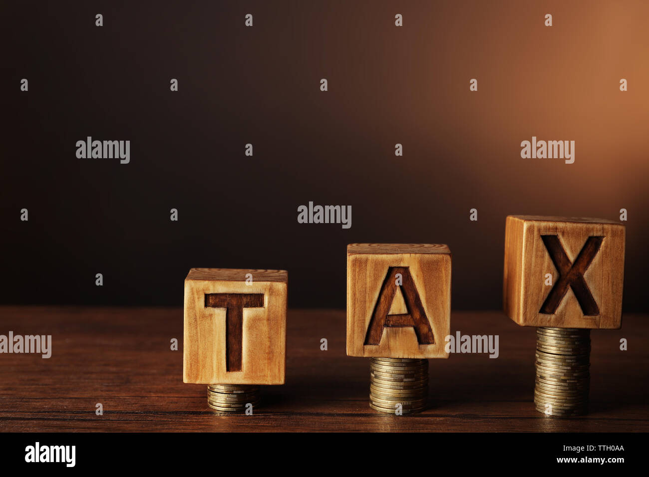 Word tax with stacked coins on dark background Stock Photo - Alamy